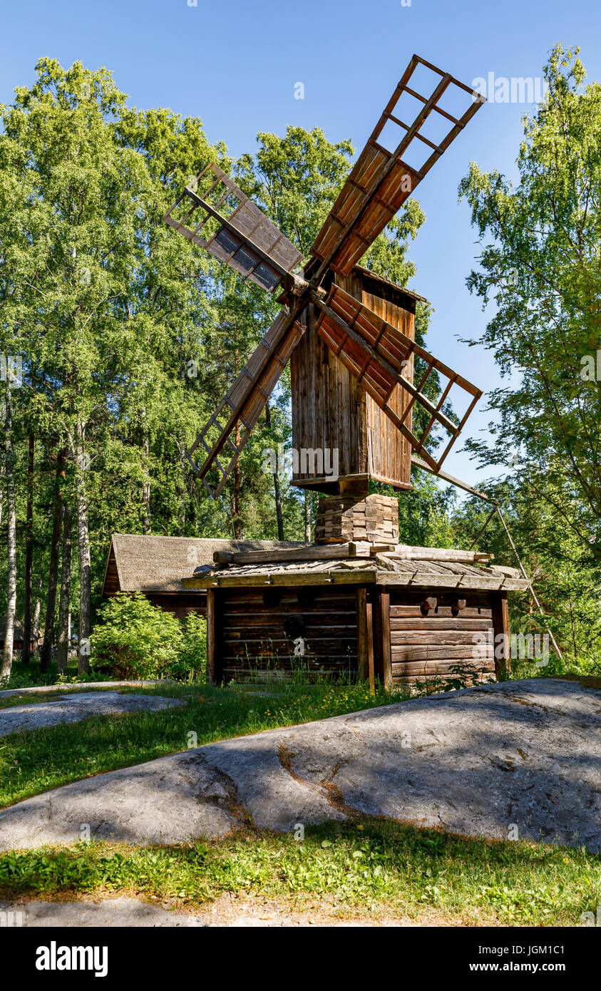 Thin ancient wooden windmill in forest in summer Stock Photo - Alamy
