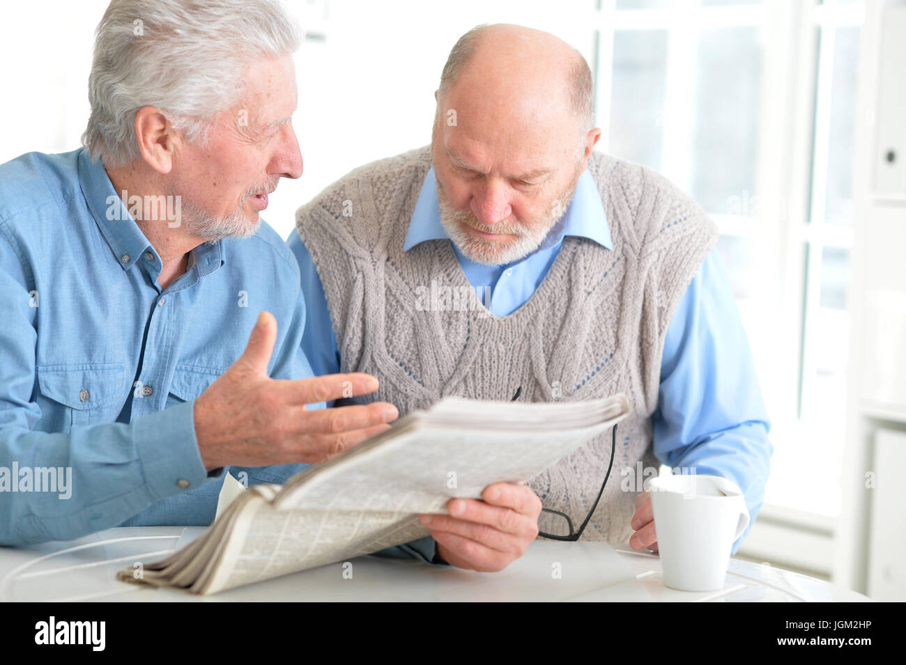 Old men reading a newspaper Stock Photo - Alamy
