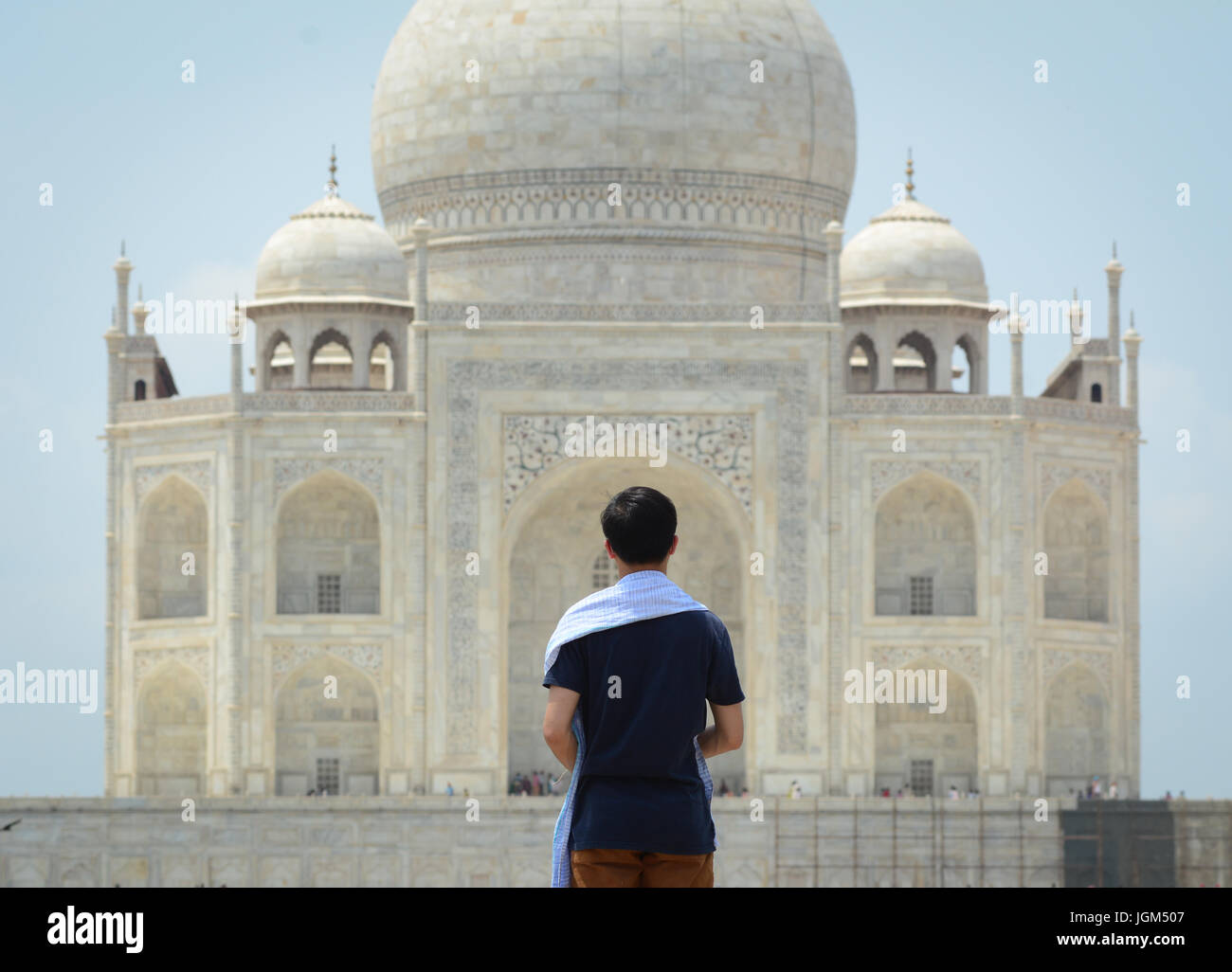 A man looking at the Taj Mahal in Agra, India. The Taj Mahal is an ...
