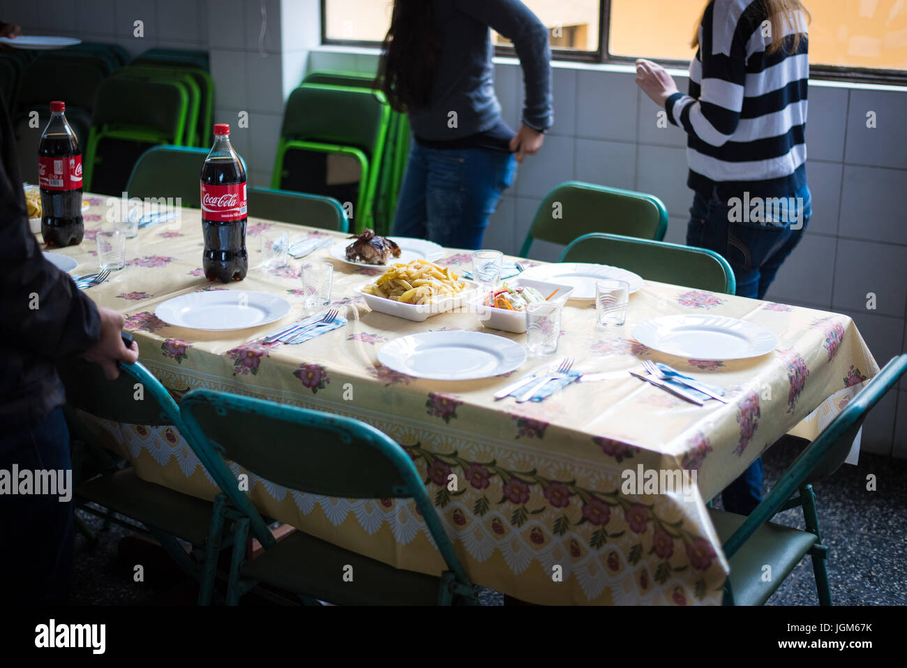 People gathering around a table for a shared fries and chicken dinner w ...
