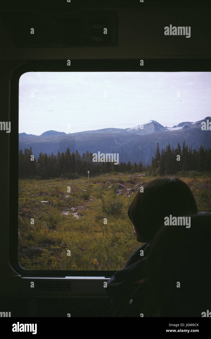 Girl looking out a train window toward a forest Stock Photo - Alamy