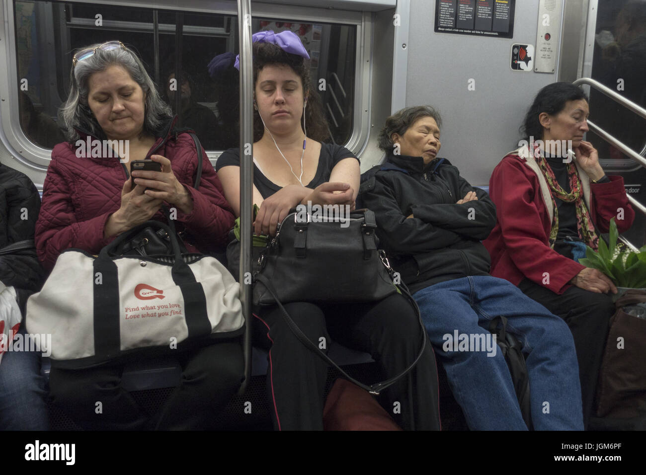 People riding a subway train after a long day on the west side of ...