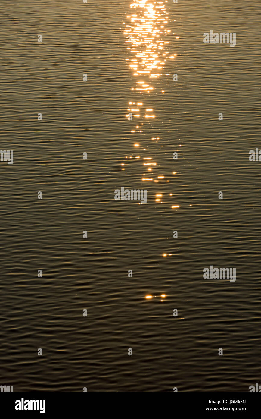 Glistening water in the evening with sunlight and small waves Stock ...