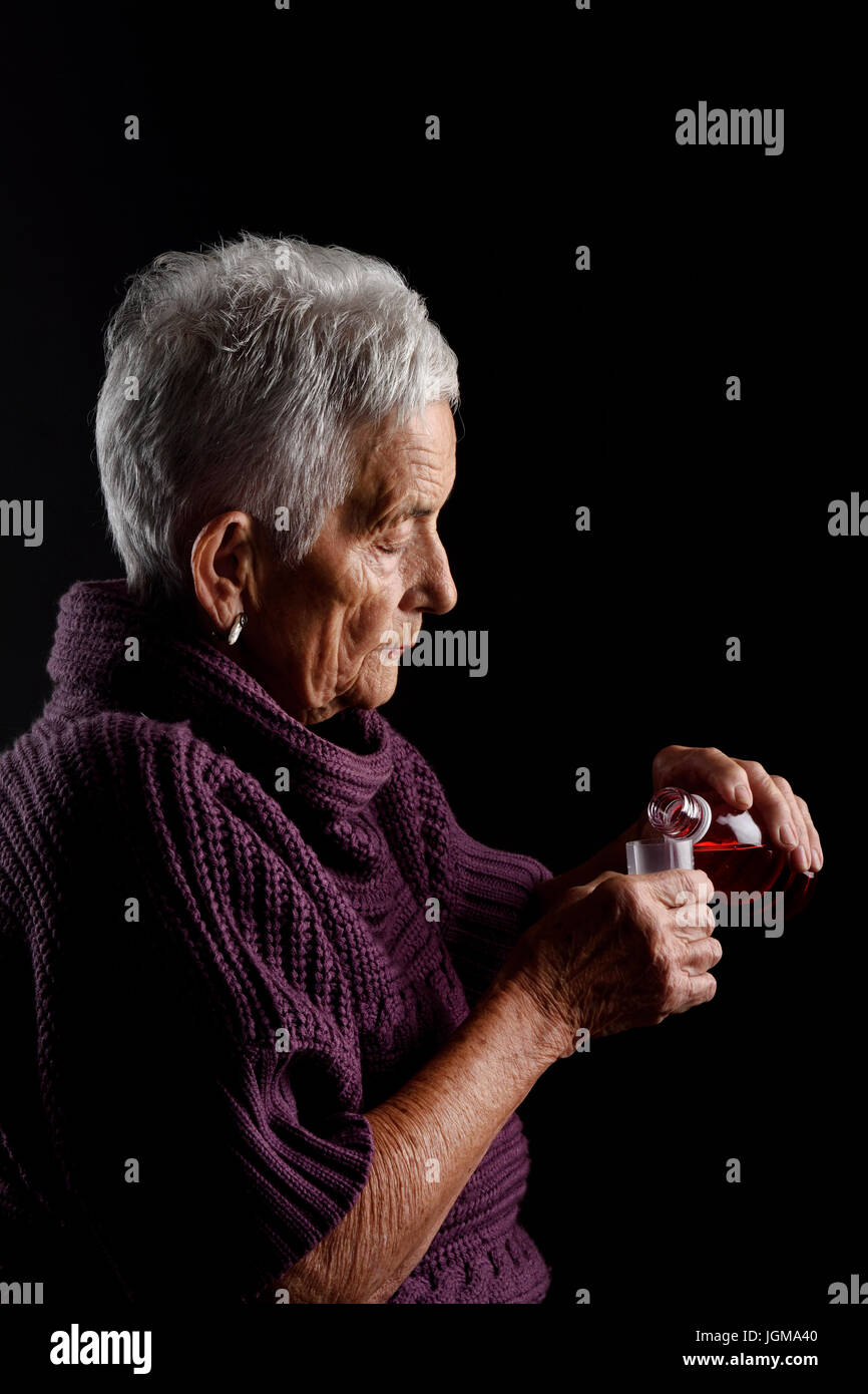 Old woman taking syrup Stock Photo - Alamy