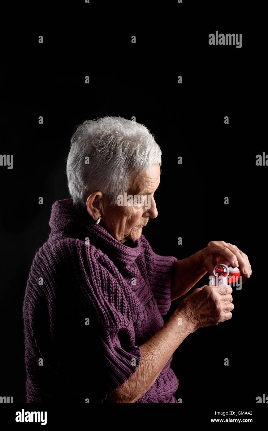 Old woman taking syrup Stock Photo - Alamy