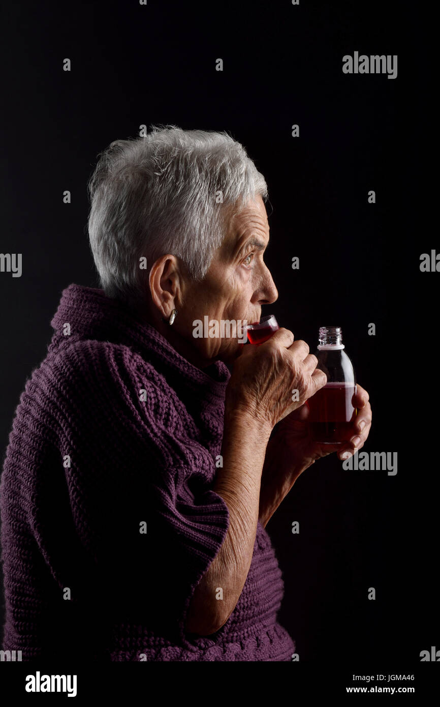 Old woman taking syrup Stock Photo - Alamy