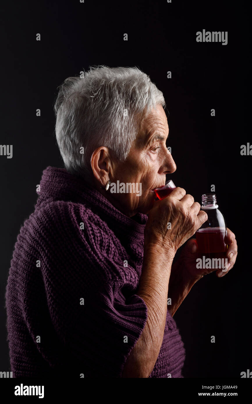 Old woman taking syrup Stock Photo - Alamy