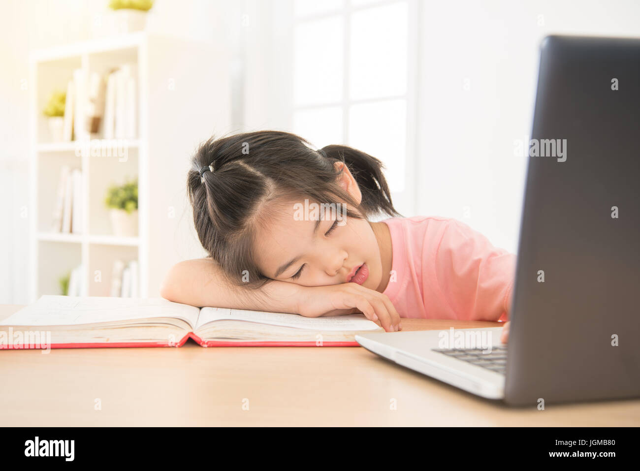 pink clothes schoolchild feeling tired sleeping on book in front of ...