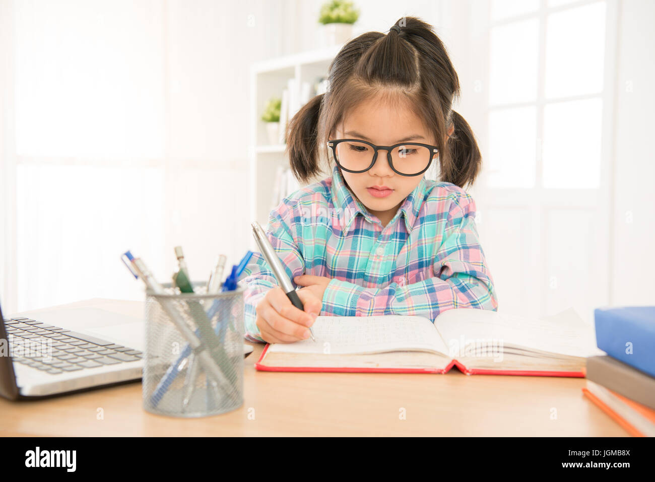 pretty cute girl kid wear glasses seriously writing homework with ...