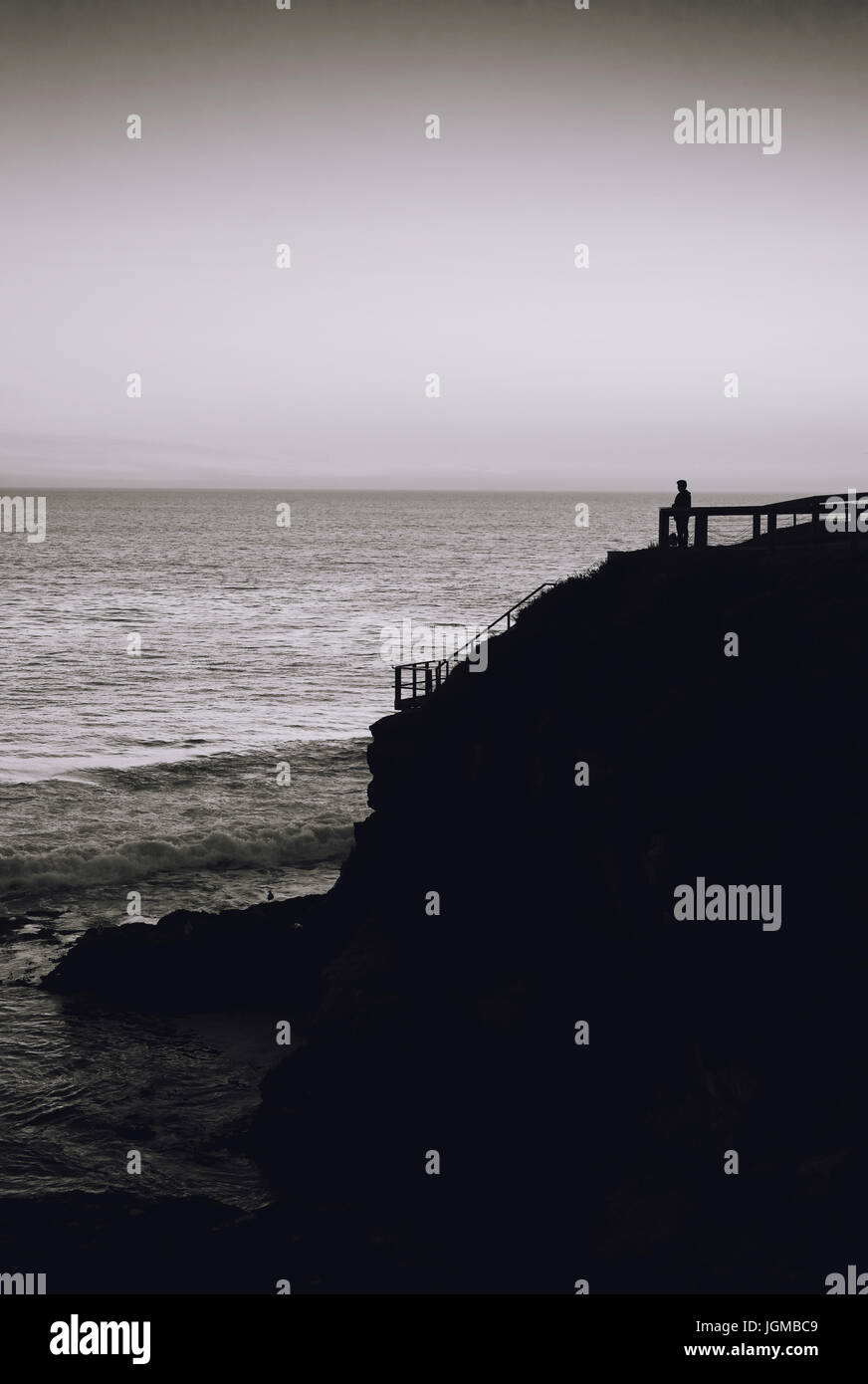 Person in the distance staring at the ocean Stock Photo - Alamy