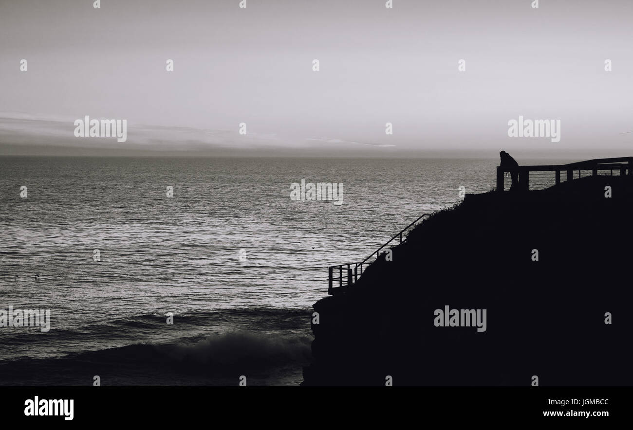 Person in the distance staring at the ocean Stock Photo - Alamy