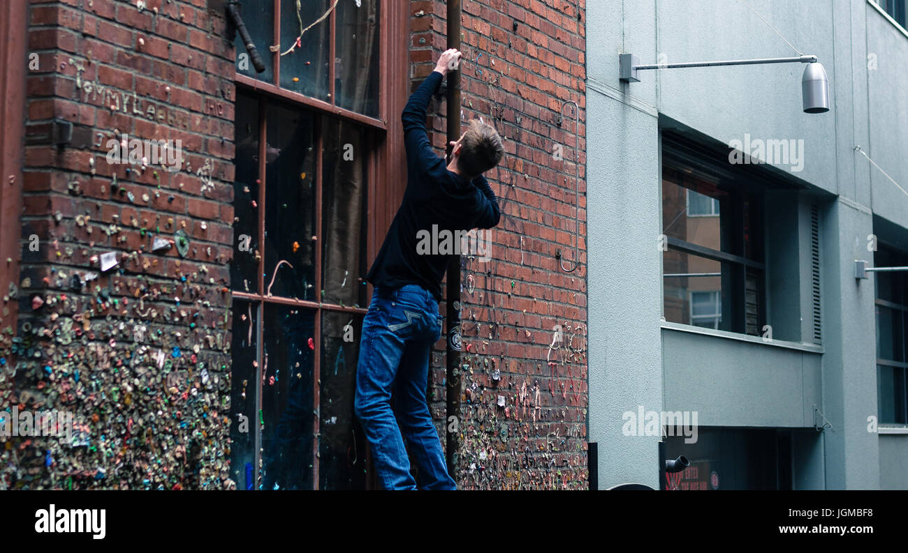 Boy climbing a window ledge in Seattle's gum wall Stock Photo - Alamy