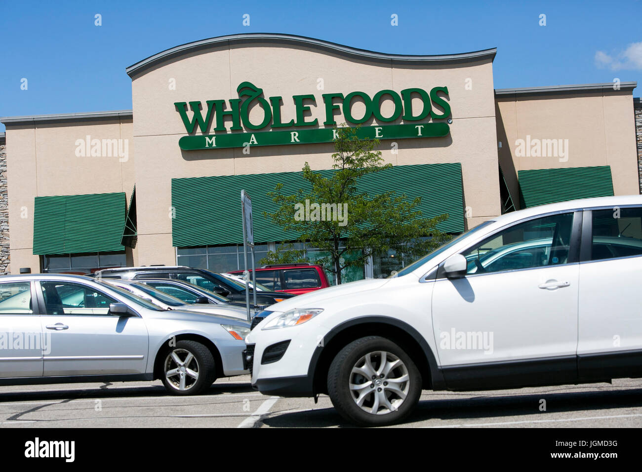A logo sign outside of a Whole Foods retail grocery store in Mason ...