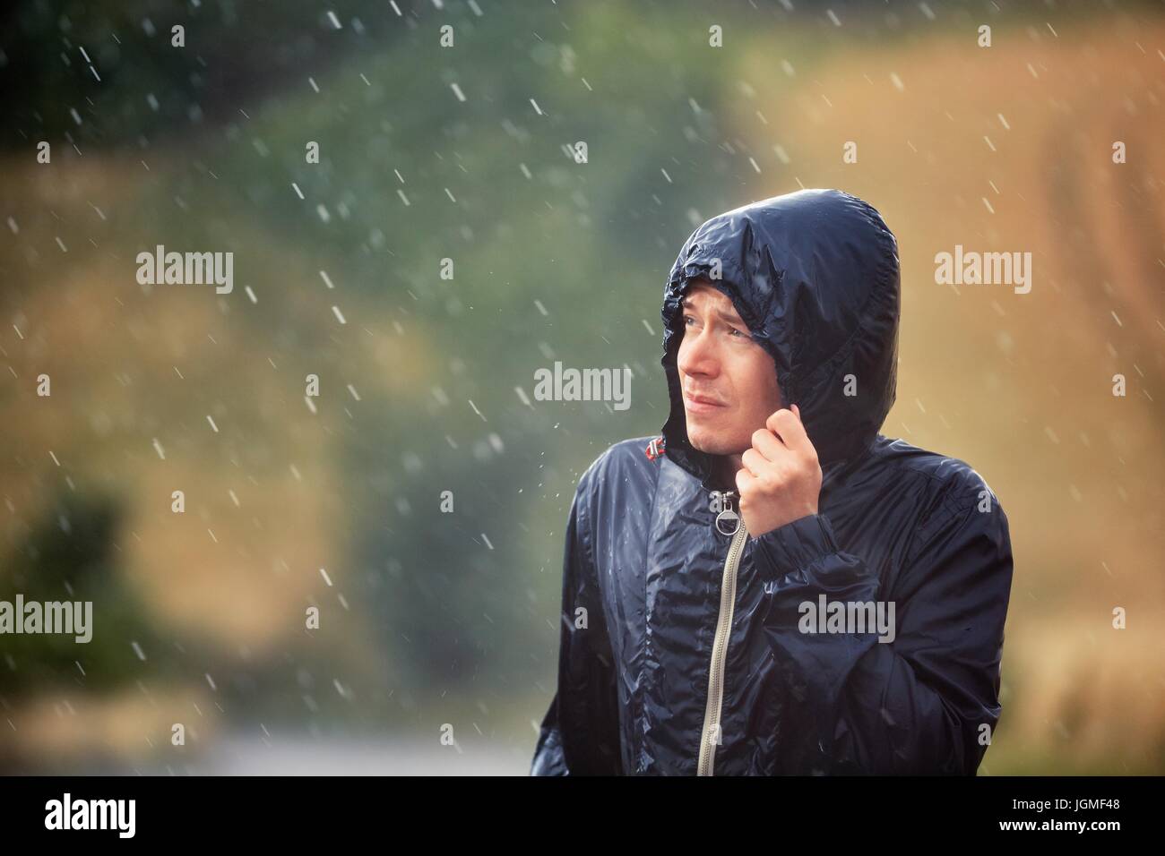 Young man walking in nature during heavy rain Stock Photo - Alamy