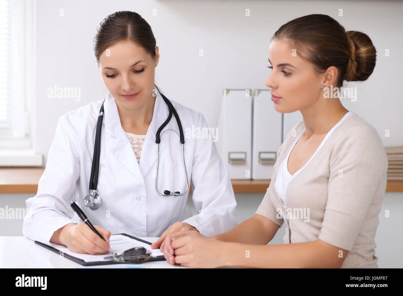 Doctor and patient sitting at the desk. The physician or therapist ...
