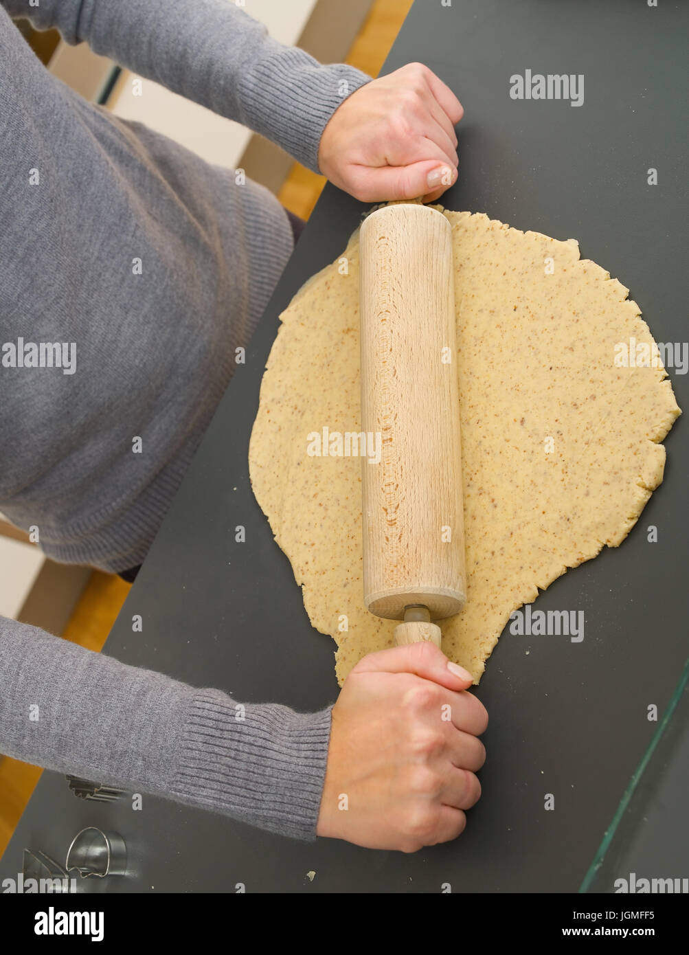 Woman rolls out with a rolling-pin the biscuit dough - woman with ...