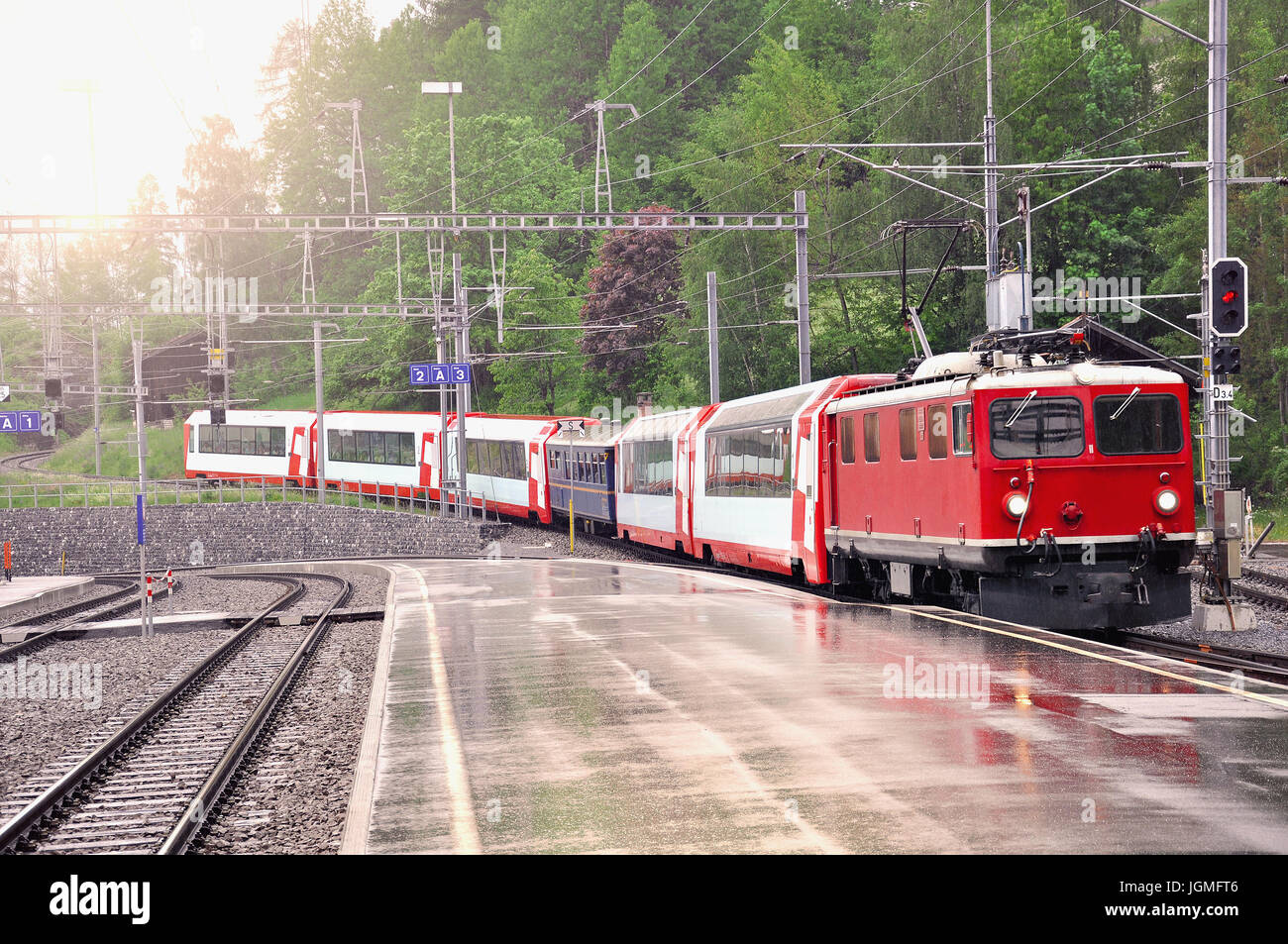 Train from Davos arrives to Filisur station at rainy day time ...