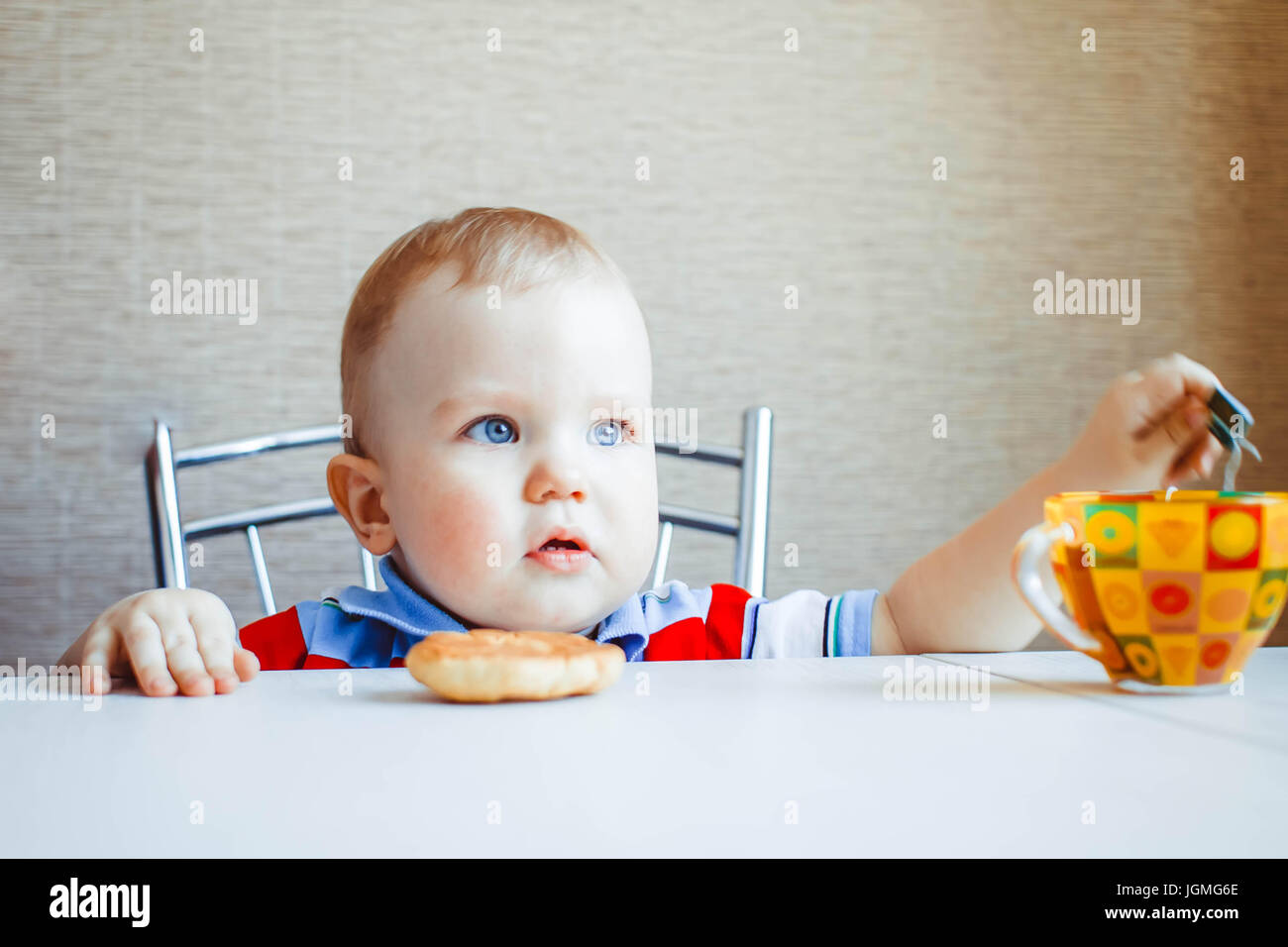 Little boy is sitting at the kitchen table Stock Photo - Alamy