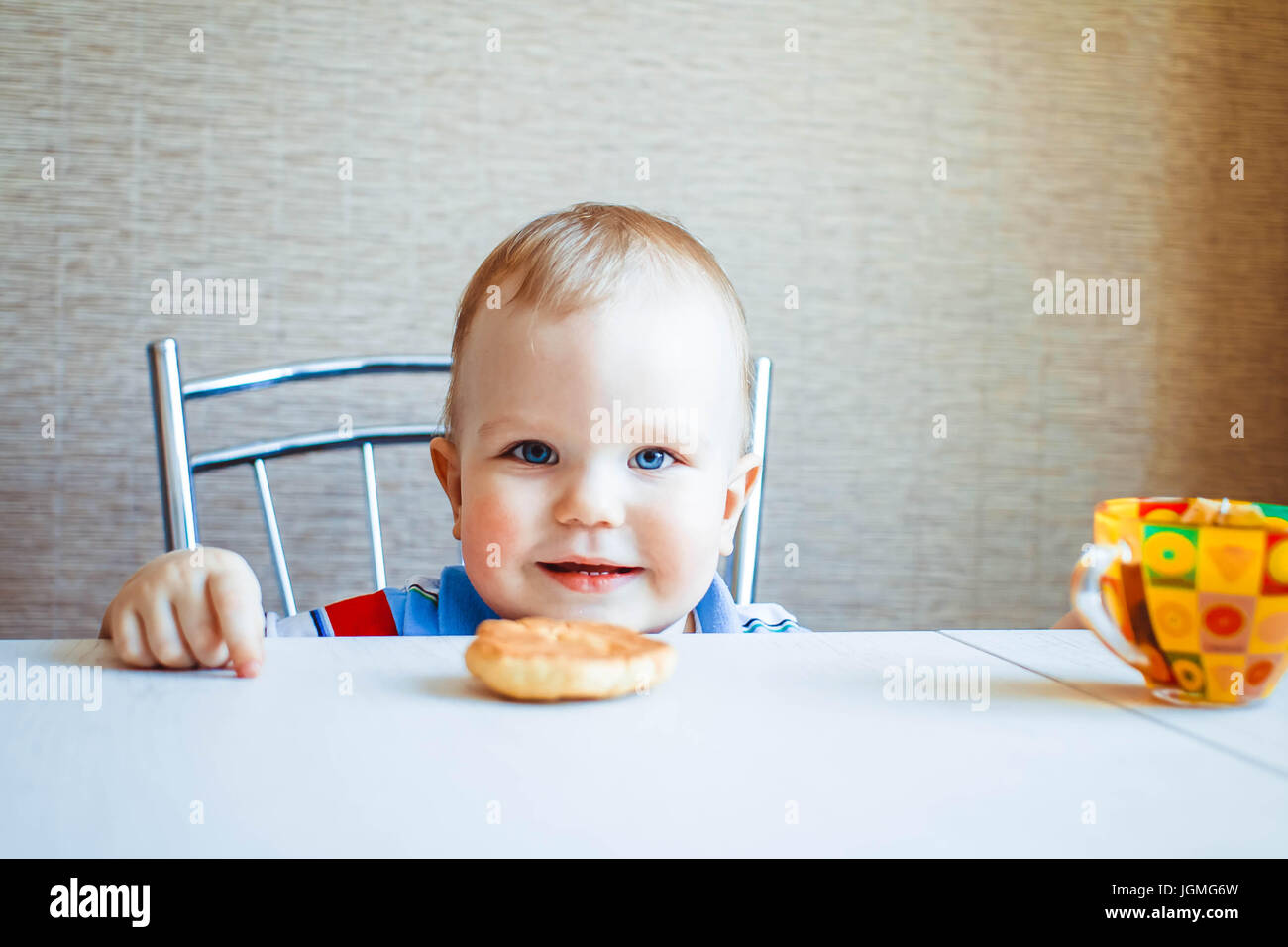 Little boy is sitting at the kitchen table Stock Photo - Alamy
