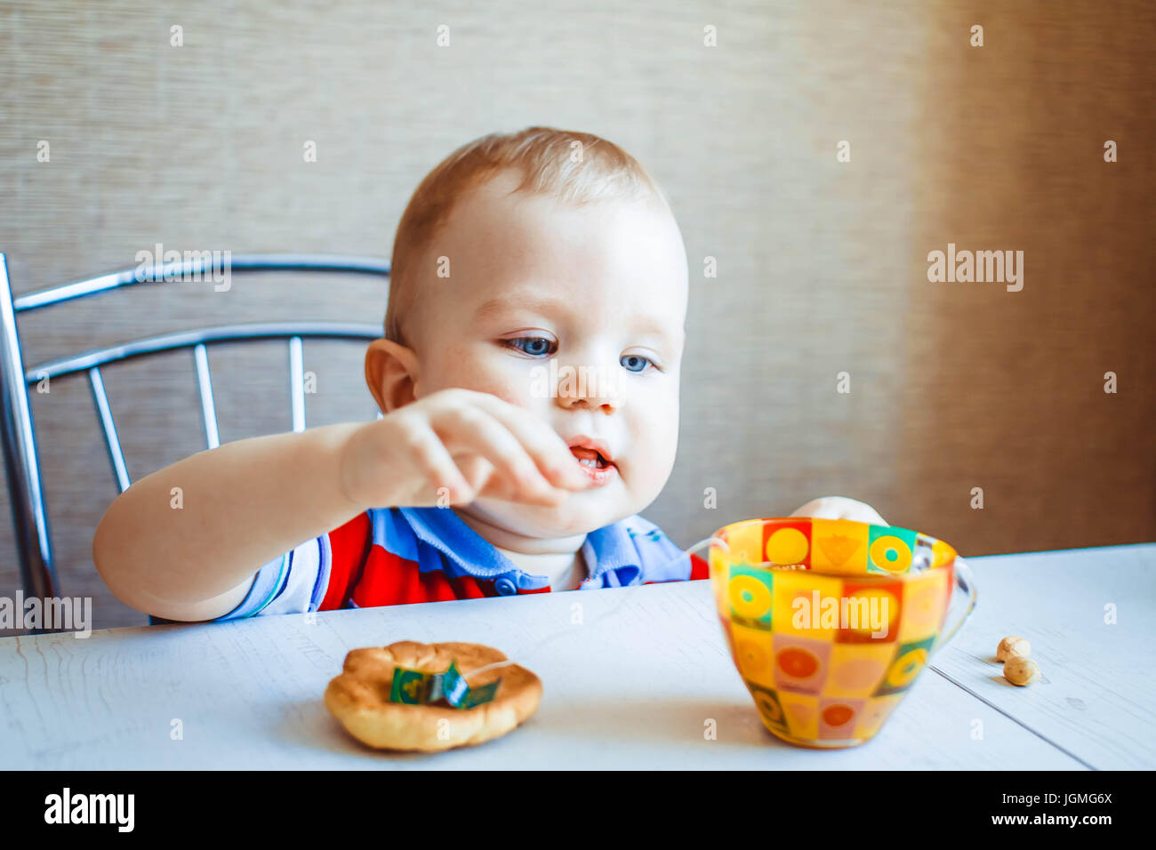 Little boy is sitting at the kitchen table Stock Photo - Alamy