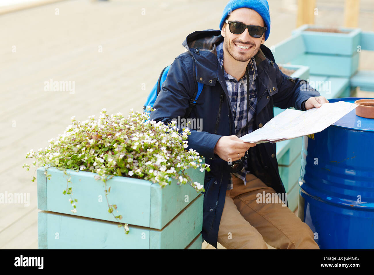 Tourist with map sitting on bench in urban environment Stock Photo - Alamy