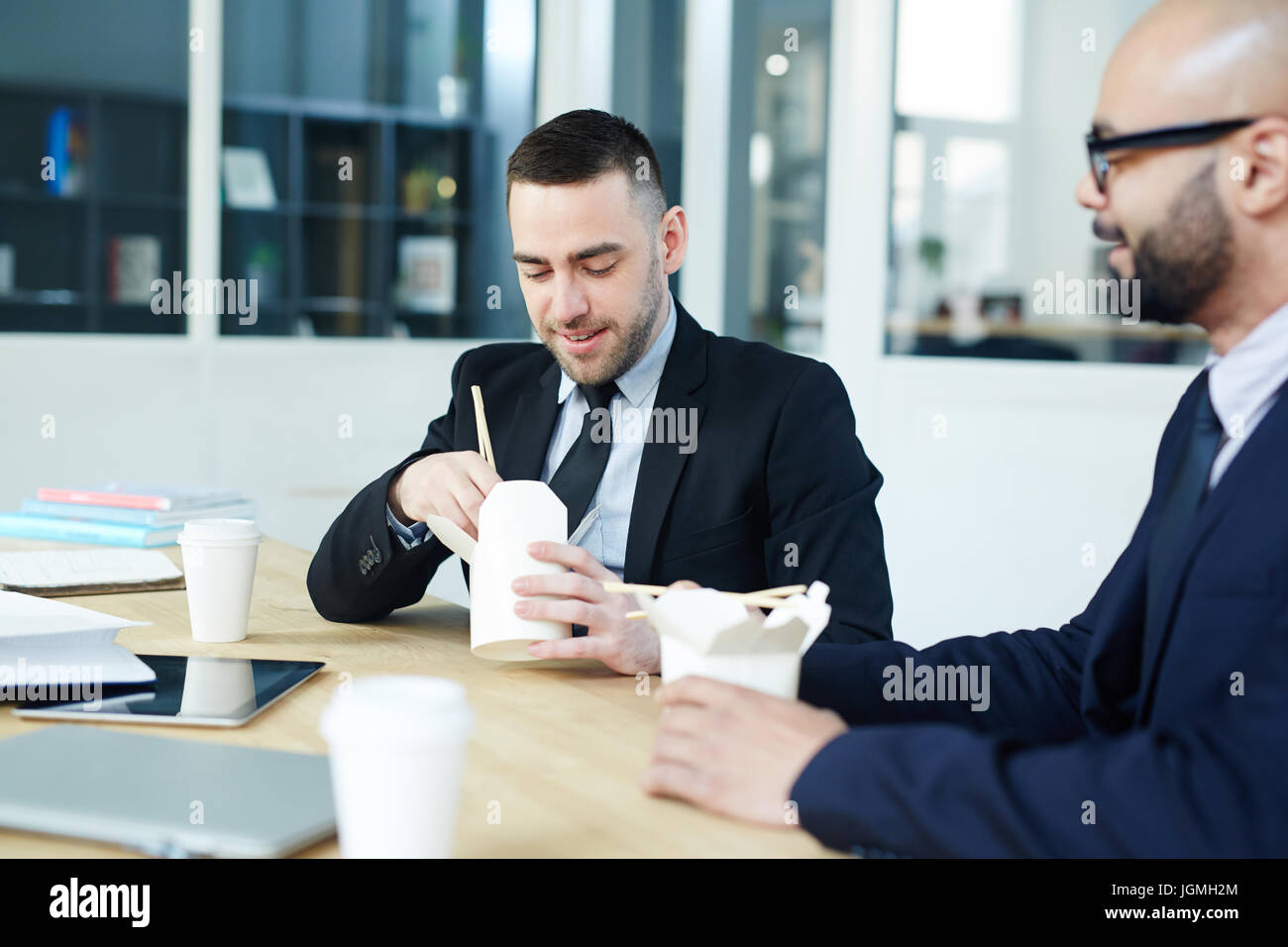 Modern office workers eating chinese wok at lunch break Stock Photo - Alamy