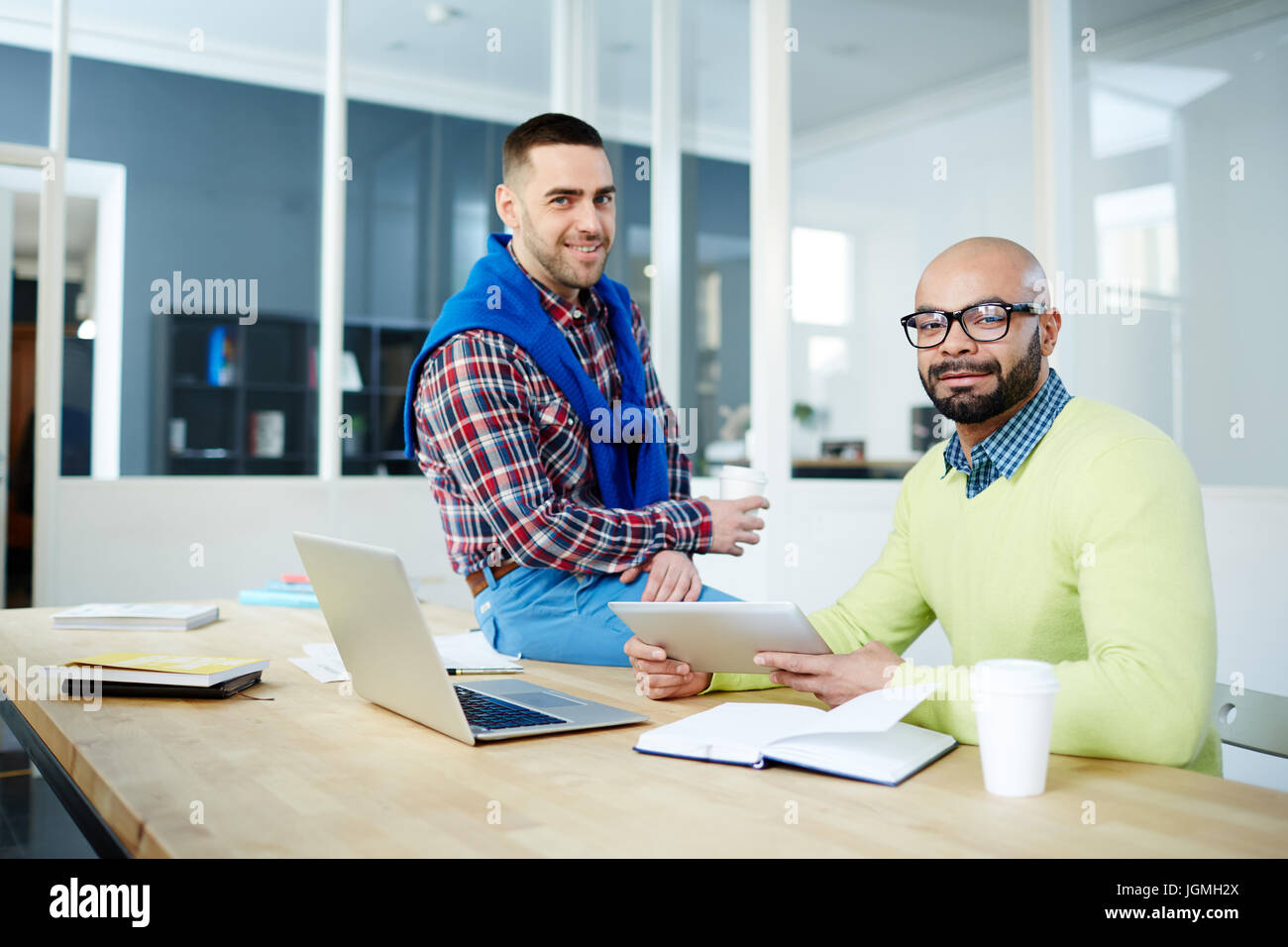 Happy young co-workers having coffee break in office Stock Photo - Alamy