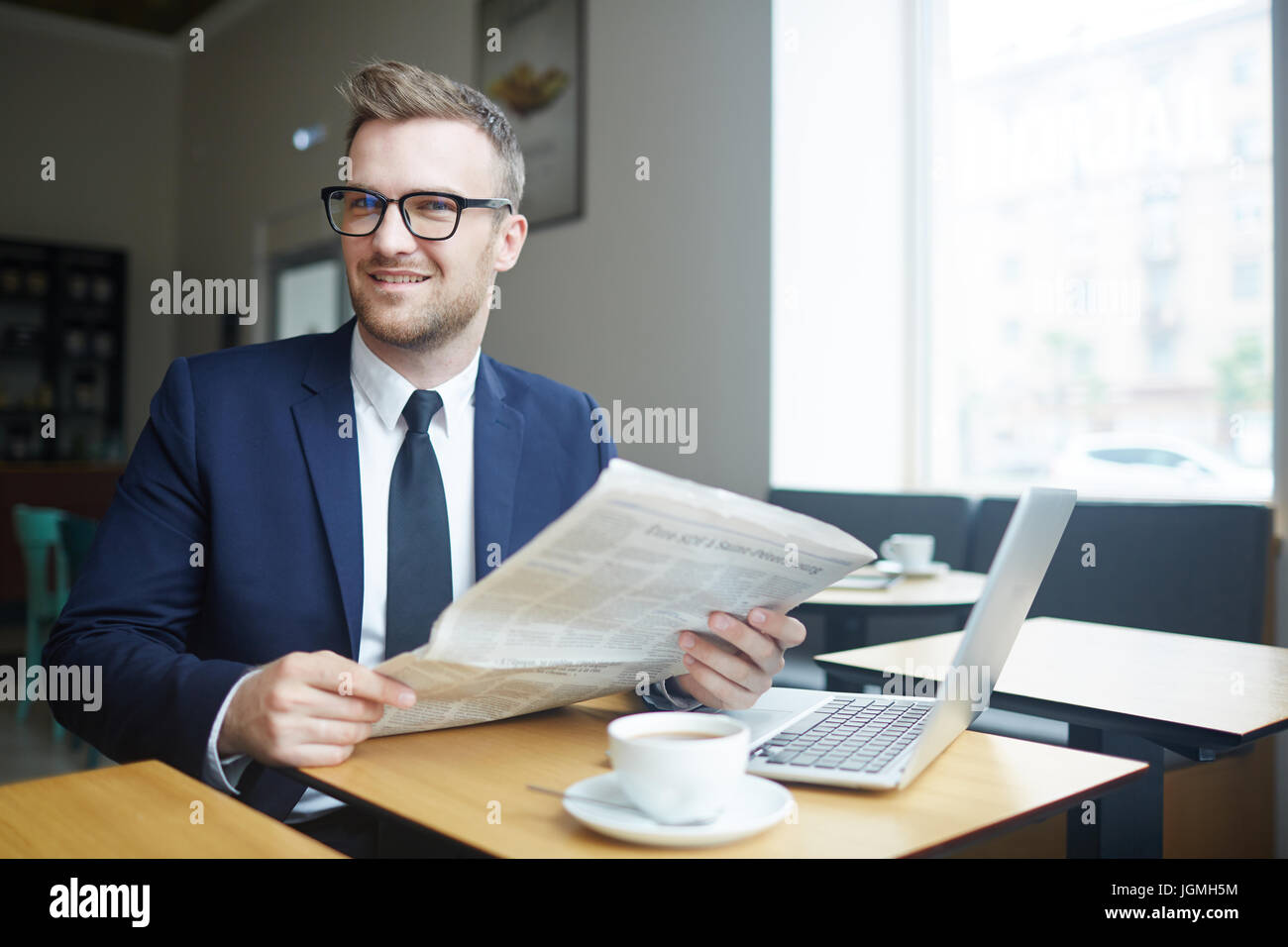 Successful leader with newspaper sitting in cafe Stock Photo - Alamy