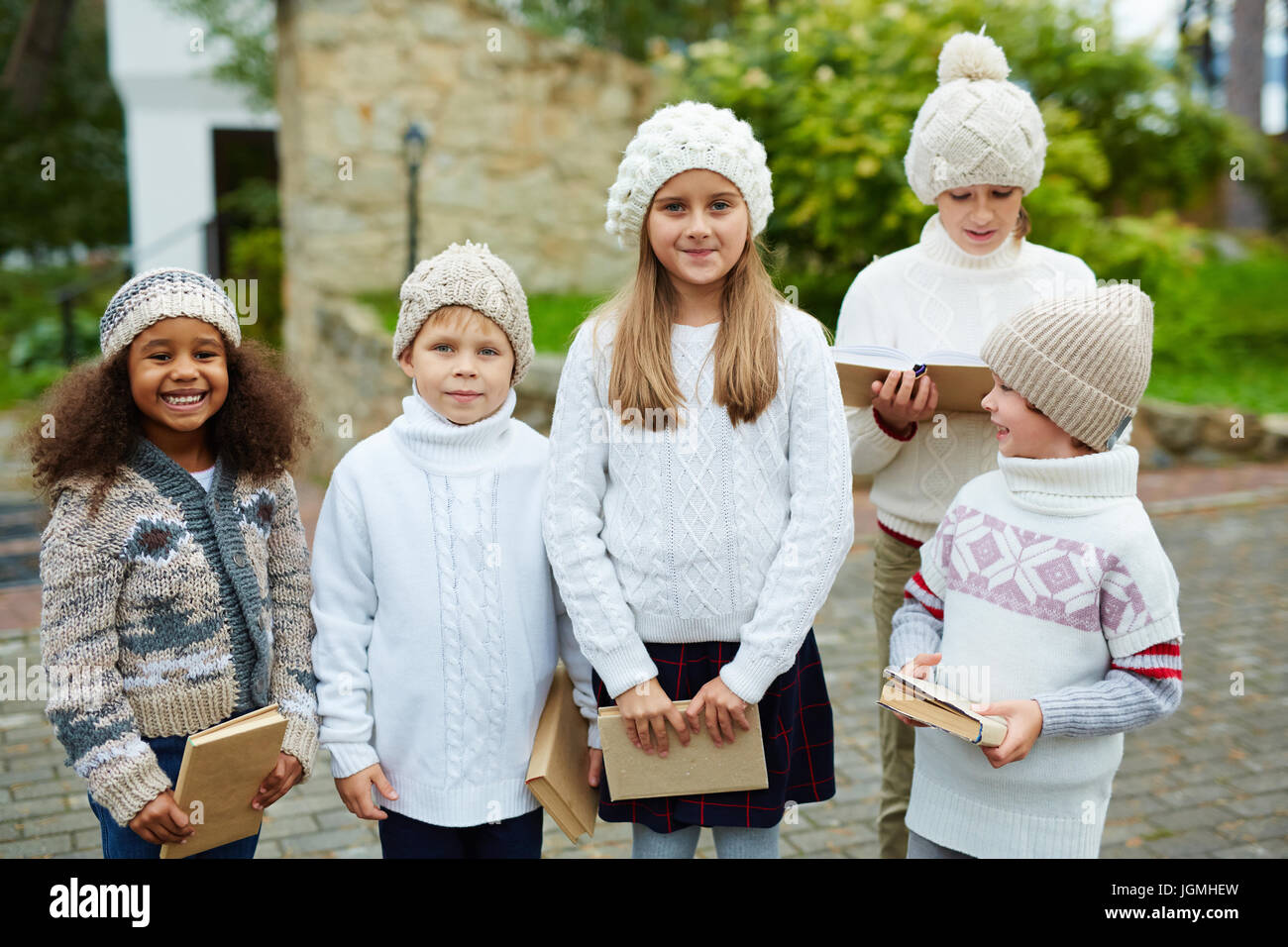 Children of various ages posing outdoors smiling to camera and holding ...