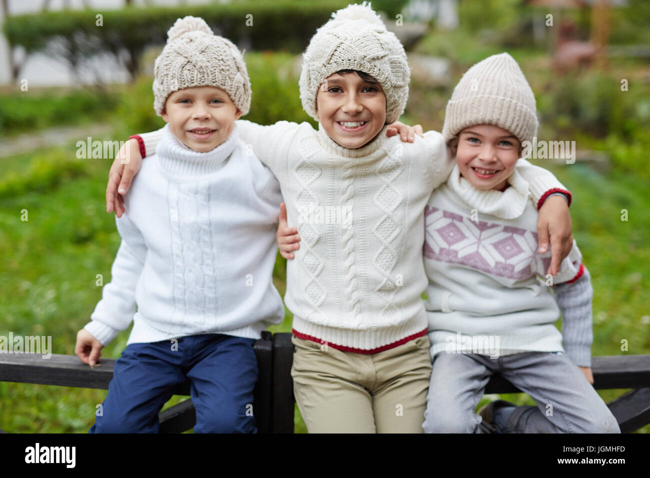Three happy boys playing outdoors in countryside, posing to camera ...