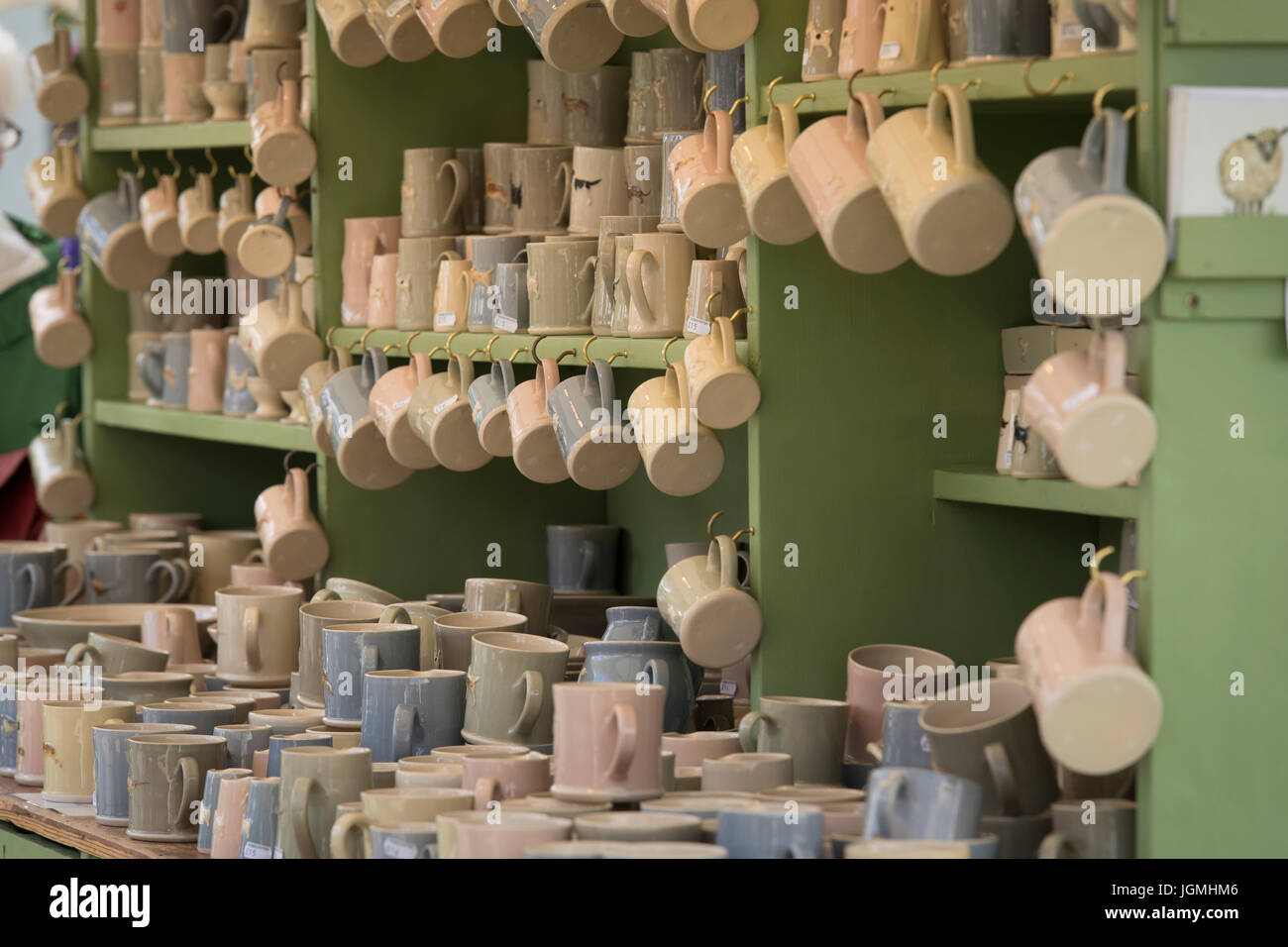 Close-up of decorative mugs, cups & jugs displayed on pottery trade ...