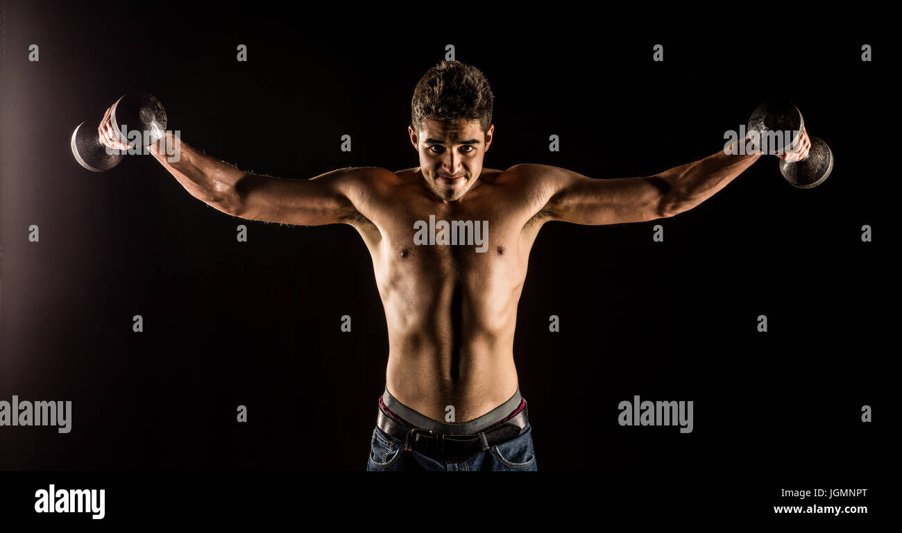 Man stretching arms outward doing a Standing Dumbbell Chest Fly. Studio ...