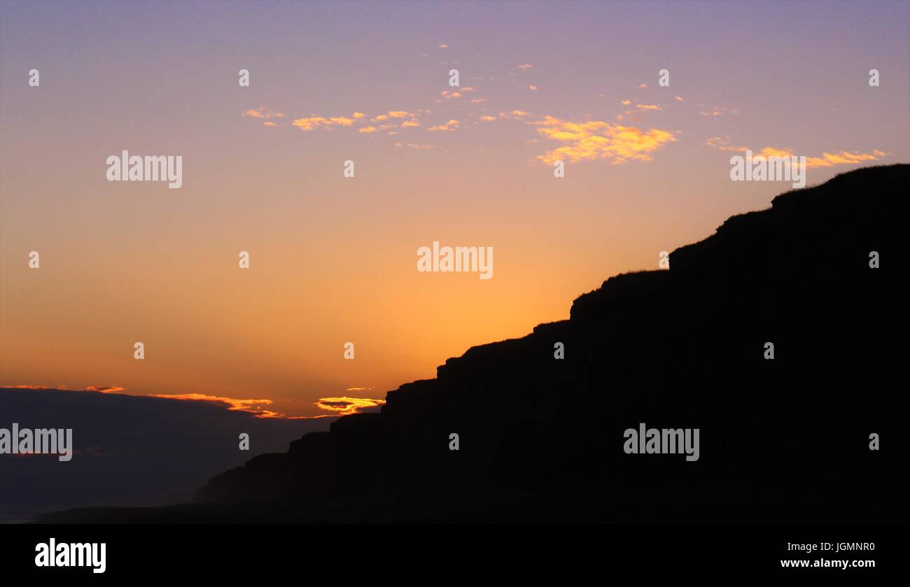 sunset over cliff face Stock Photo - Alamy