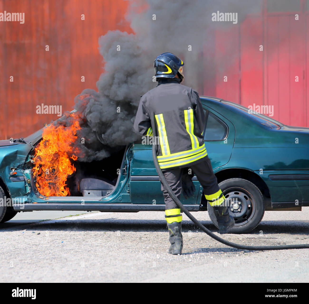broken car with flames and black smoke and firefighter intervening to ...
