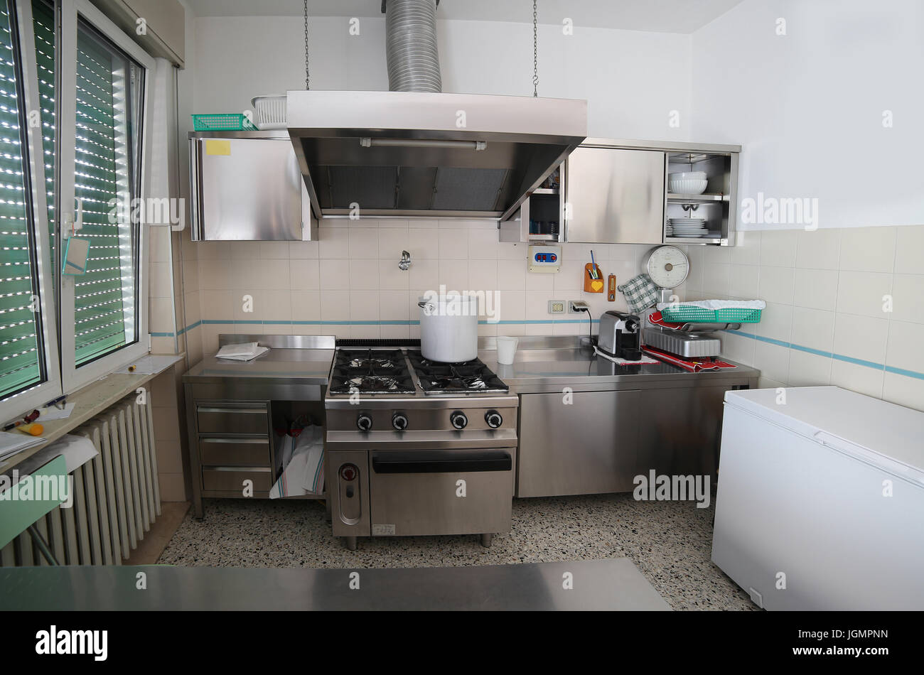wide industrial kitchen with cookers in steel stainless and a big pot ...