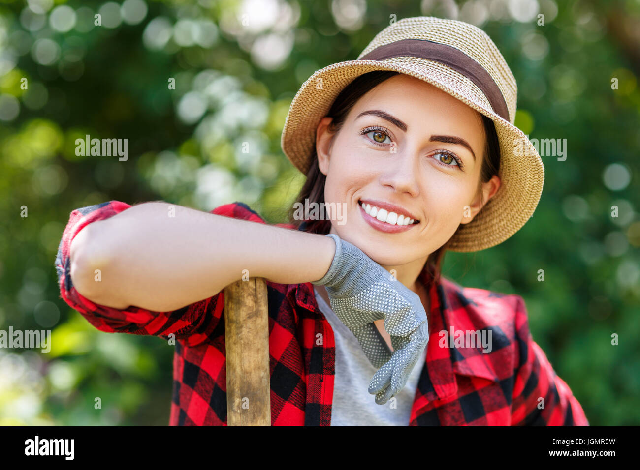 young woman gardener holding shovel in garden. People, gardening ...