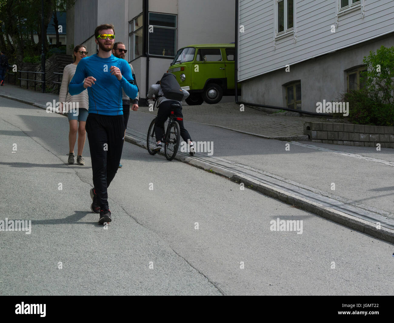 Young man running down steep hill at Brubakken a cyclist using Trampe ...