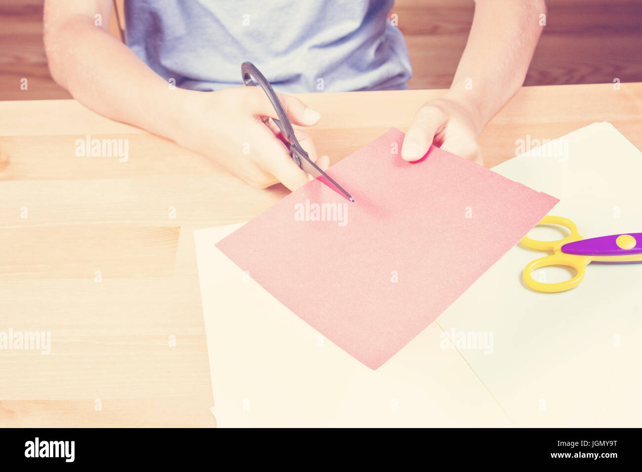 Child's hands cutting colored red paper with scissors Stock Photo - Alamy