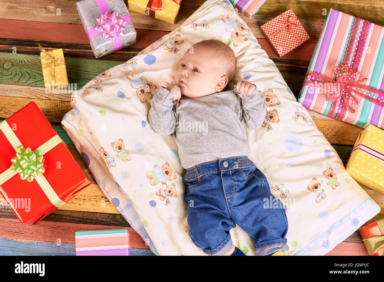 Baby and presents, top view. Caucasian child lying on pillow. First ...