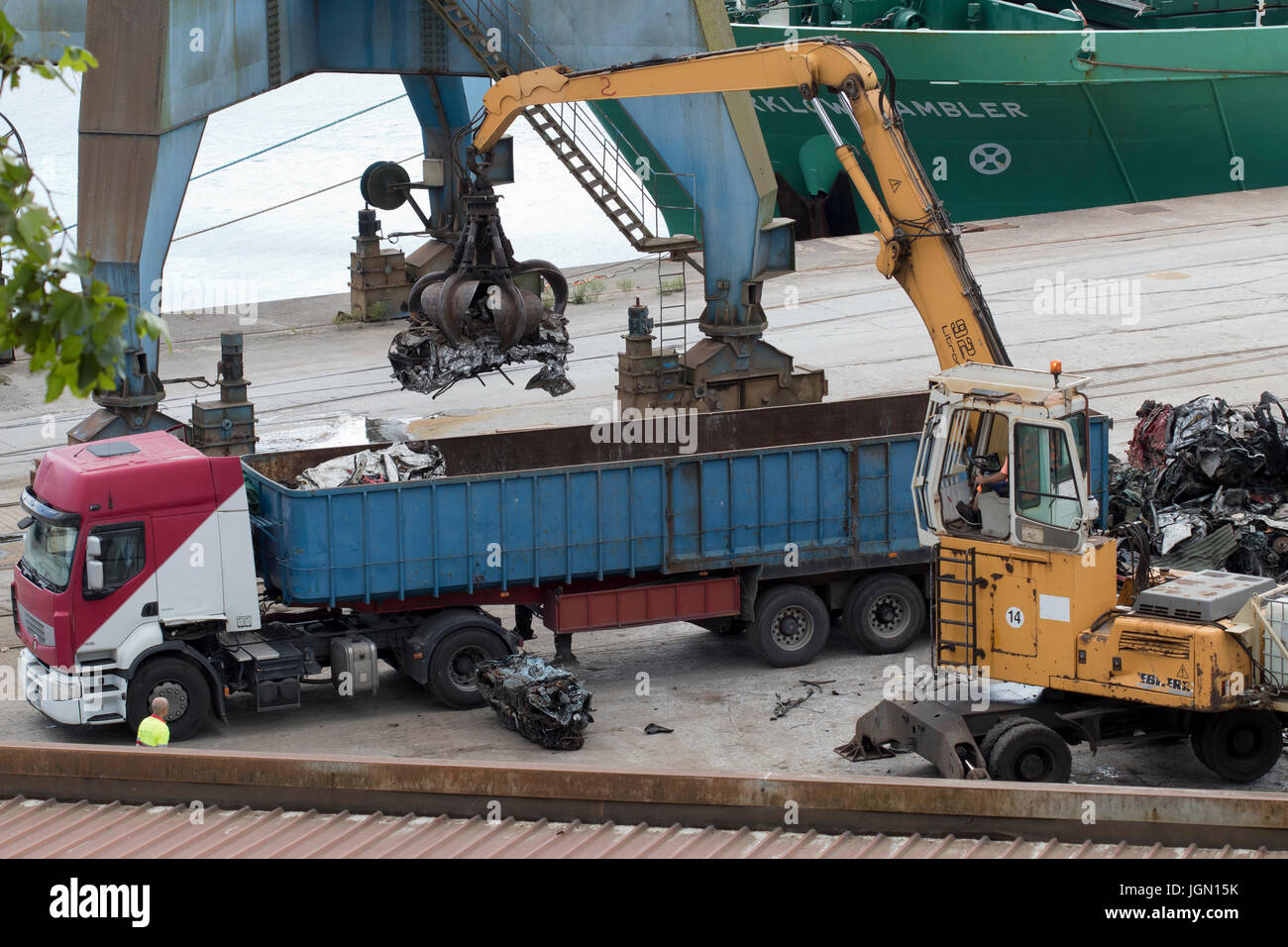 Loading scaps cars in a articulated lorry with the help of a crane, in ...