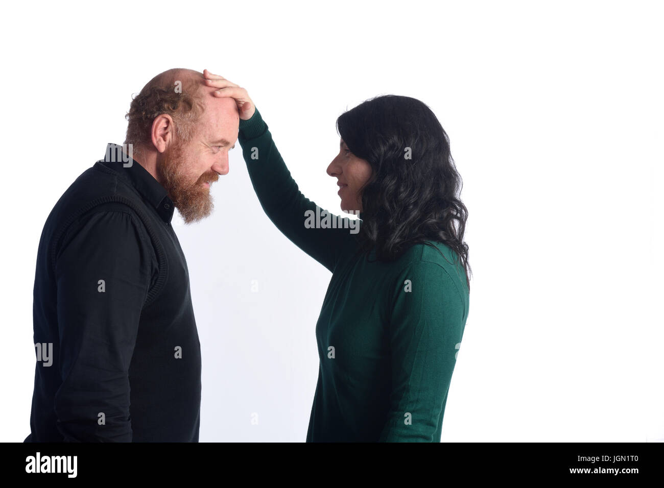 A woman touching the baldness of a man Stock Photo - Alamy