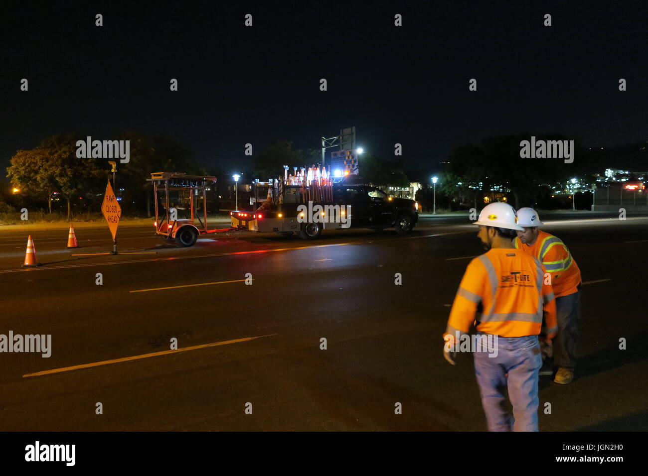 Men placing pylons on street at night Stock Photo - Alamy