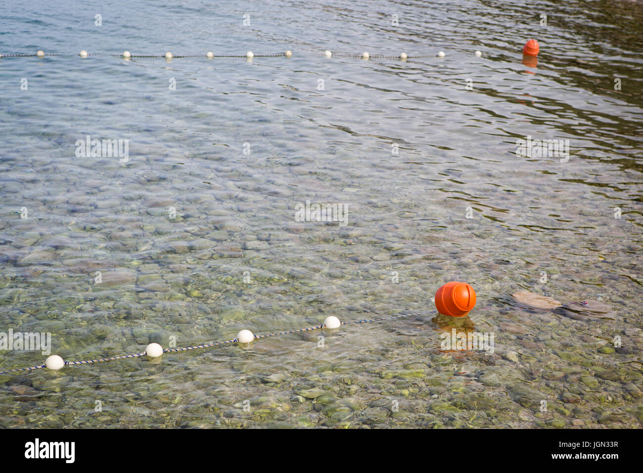 Floating orange bouys inform sailors & swimmers about dangerous rocks ...