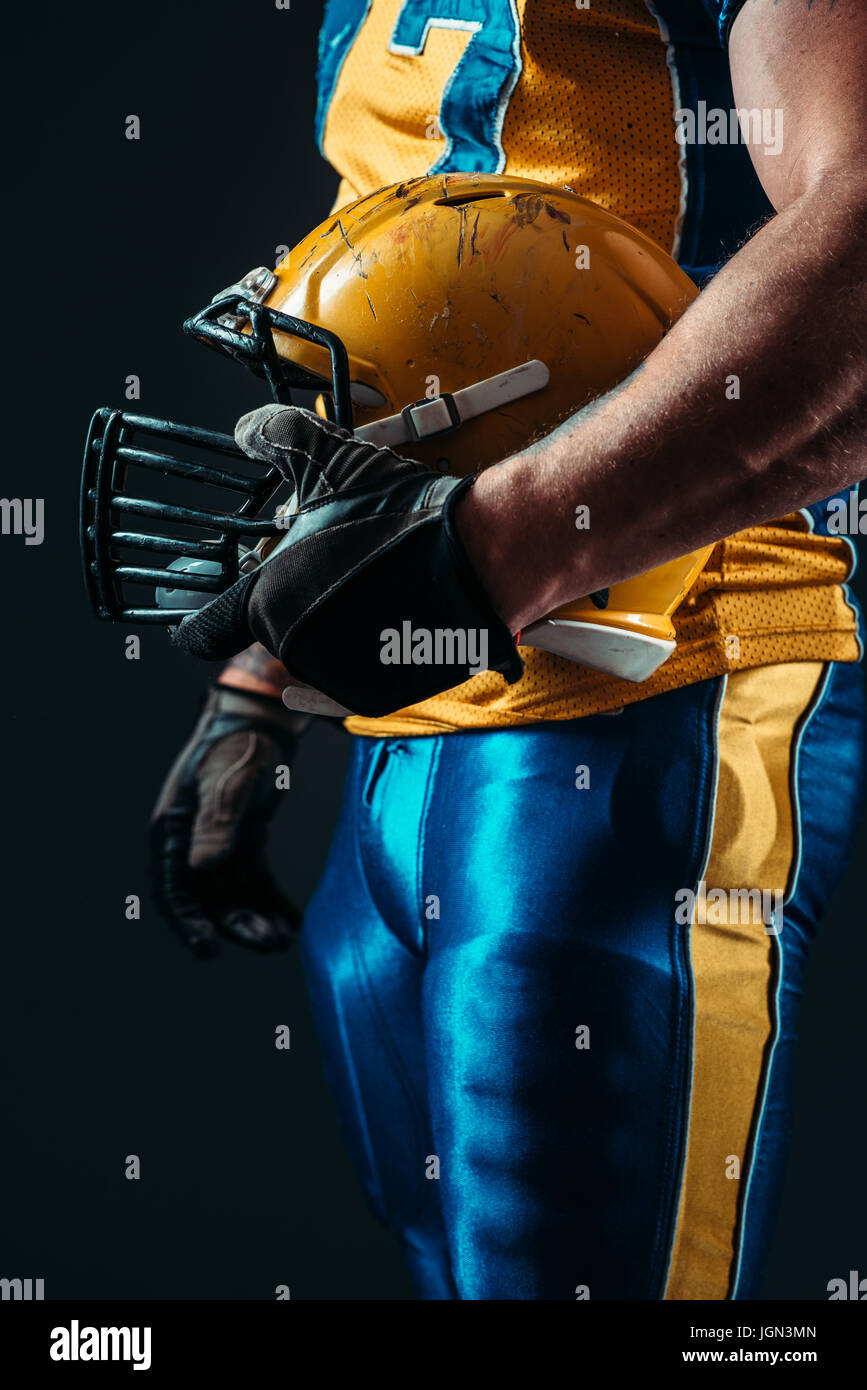 Muscular player with american football helmet in hand. Contact sport ...