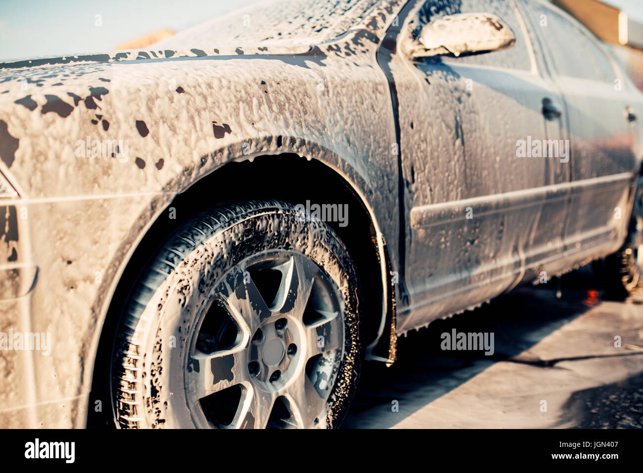 Wet vehicle in foam, automobile in suds, car wash. Carwash station ...