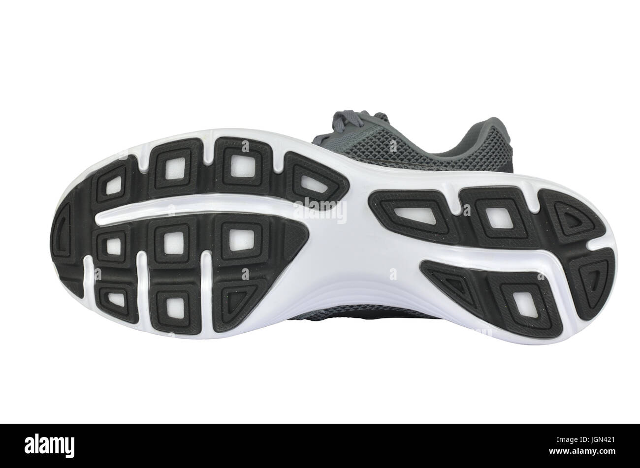 Sole of left sneaker and one sneaker behind it isolated on white ...