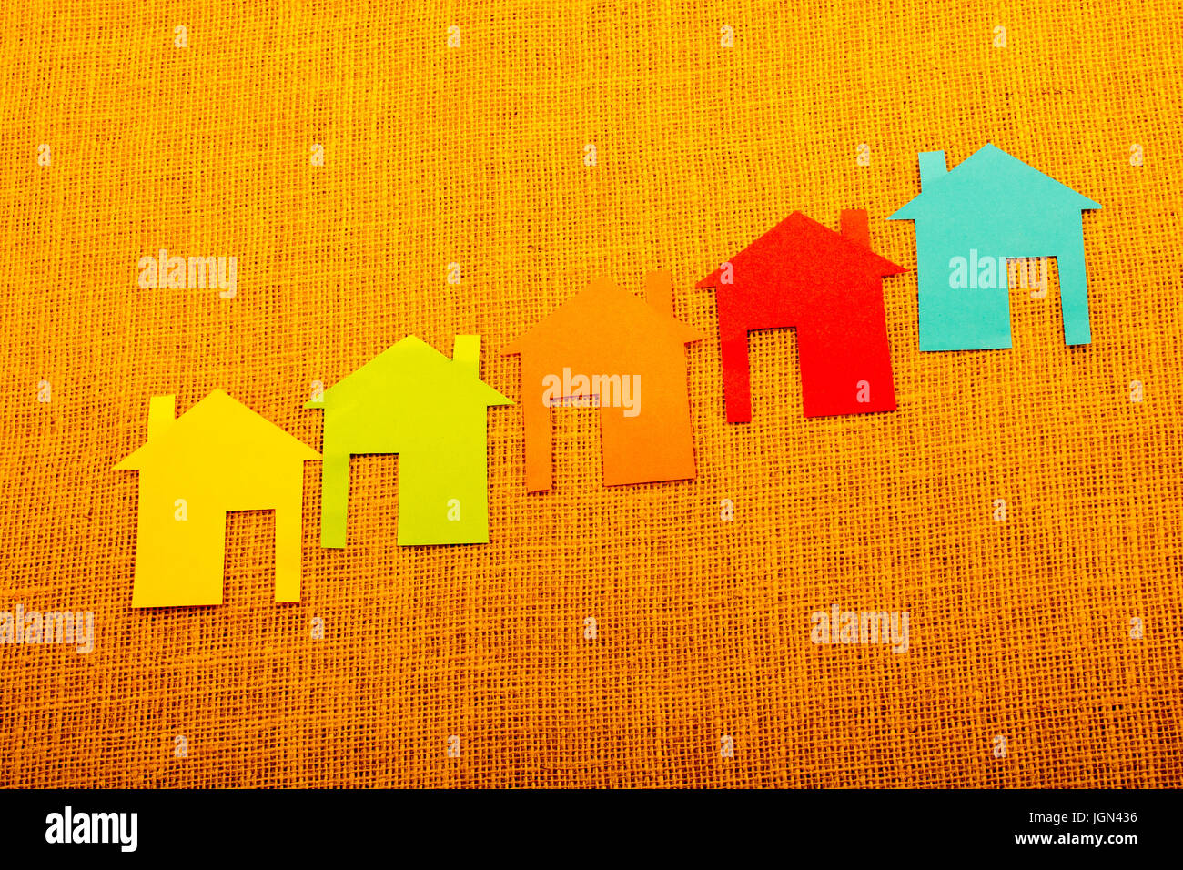 Little house shape cut out of colorful paper on a canvas background ...
