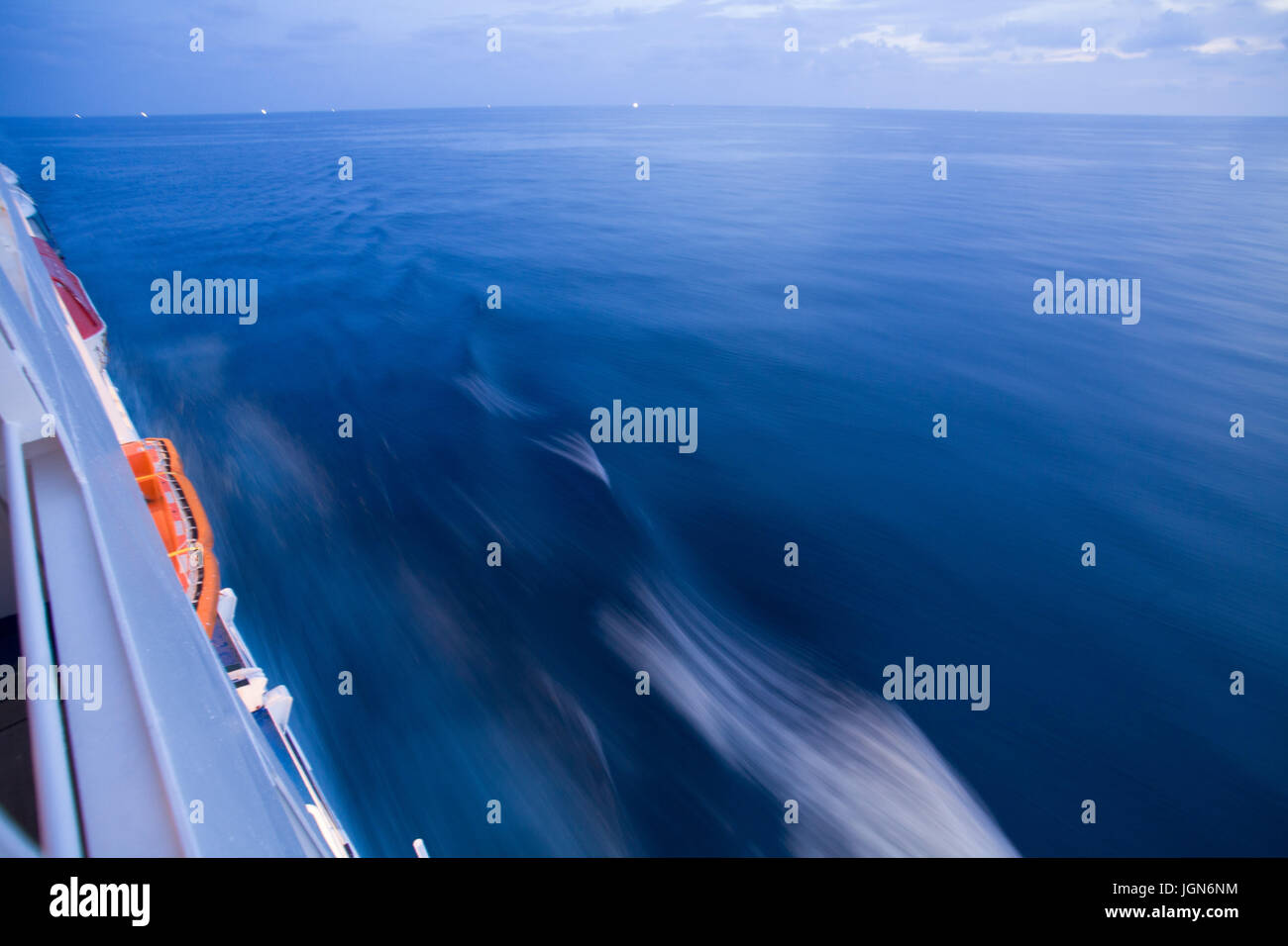 Freighter sailing across the ocean with a rainbow Touching the ship ...
