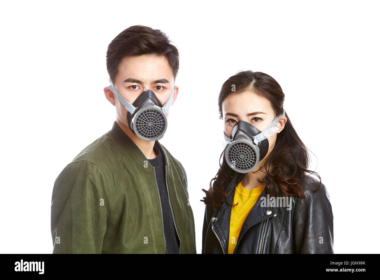 young asian couple wearing gas mask staring at camera, isolated on ...