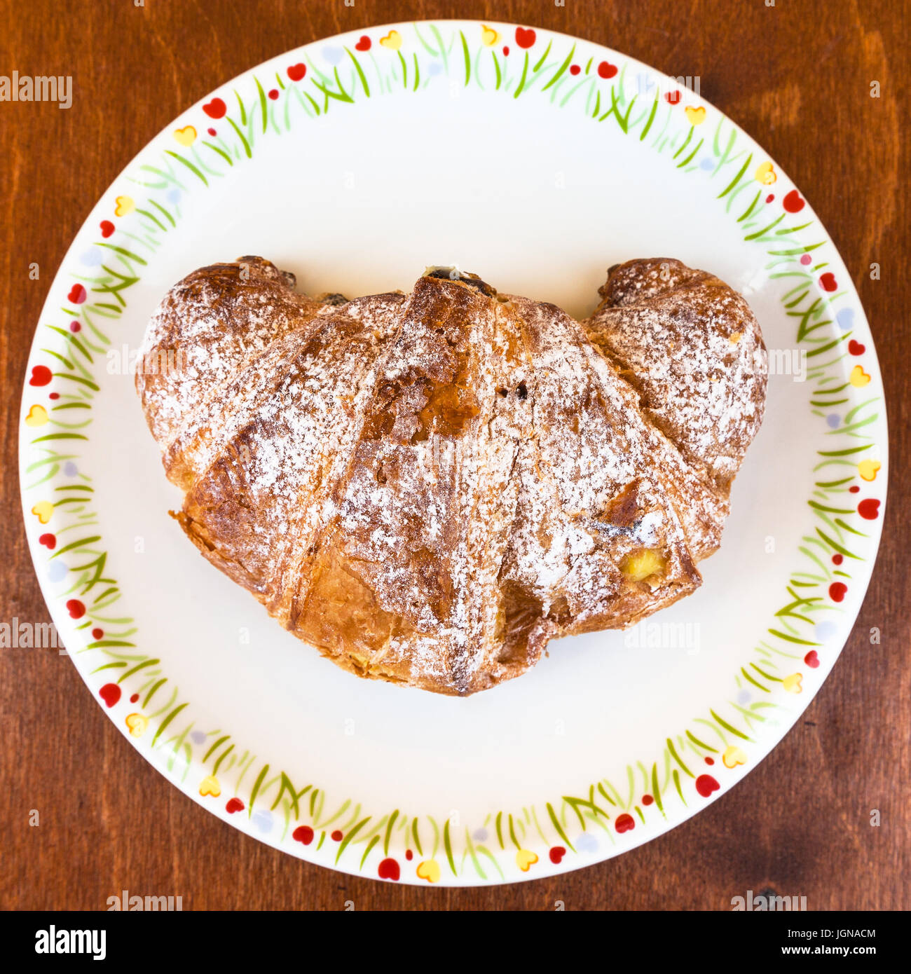 top view of fresh italian croissant filled by vanilla cream on wooden ...